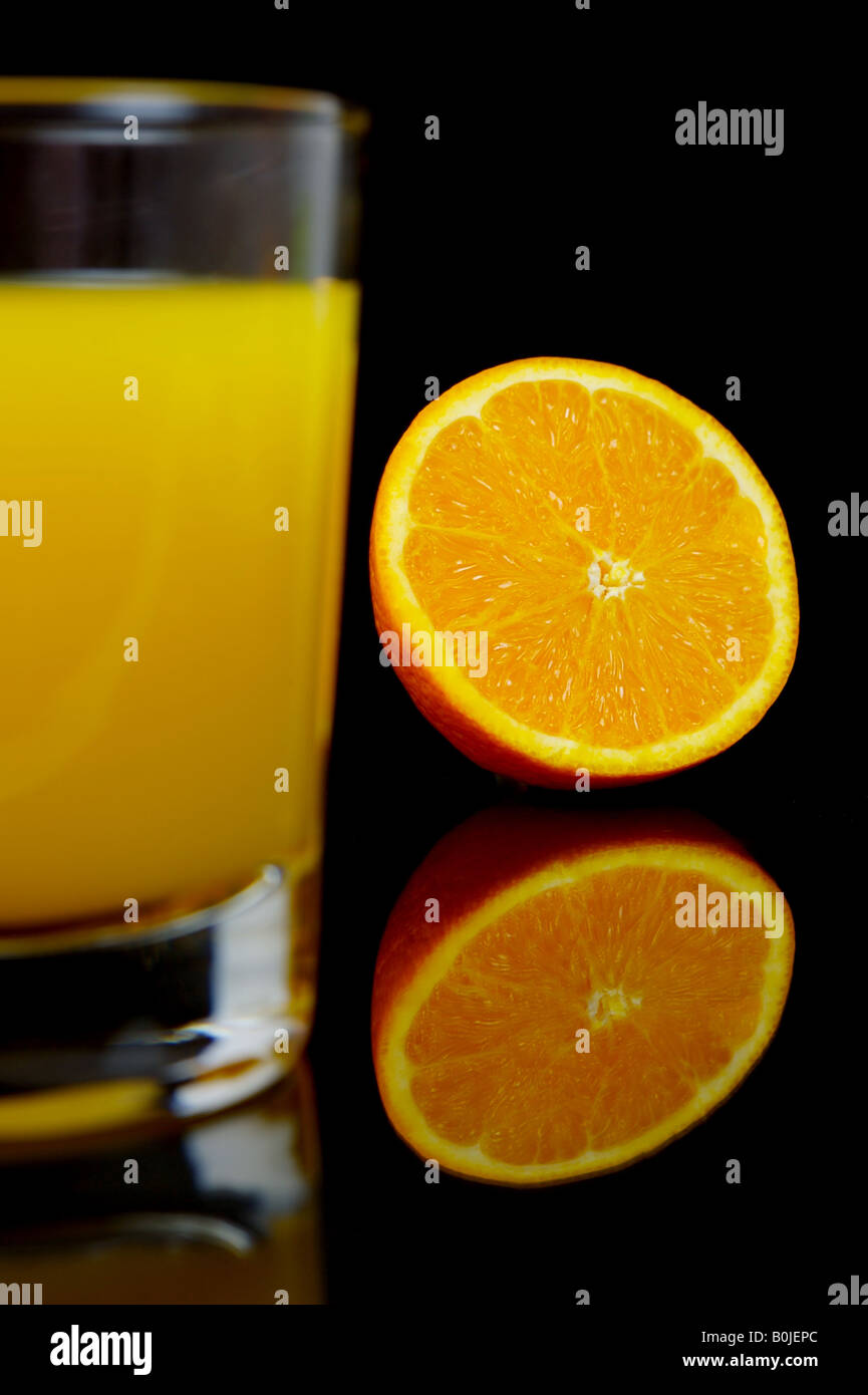 Orange juice isolated against a black background Stock Photo - Alamy