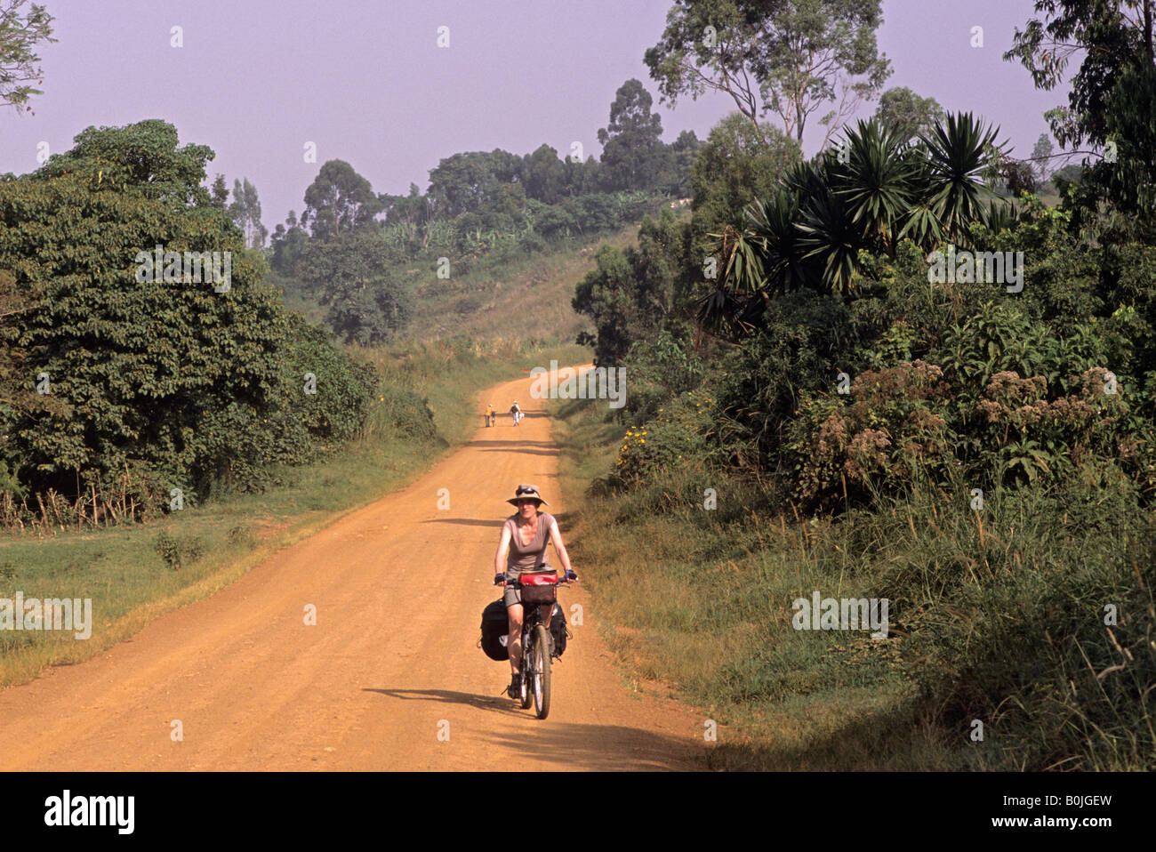 female white touring cyclist on rough dirt road in Uganda Africa Stock ...