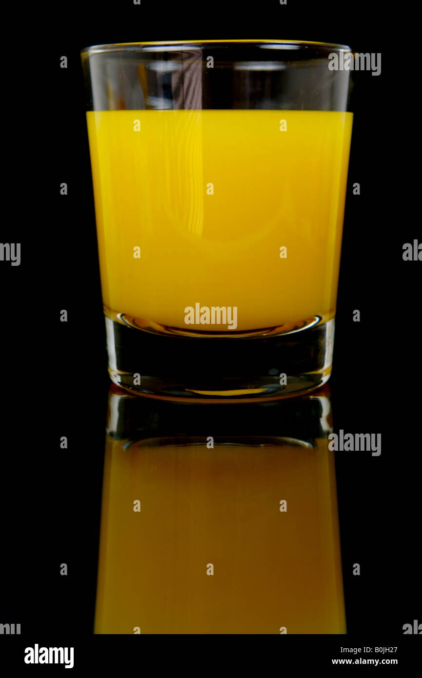 Orange juice isolated against a black background Stock Photo - Alamy