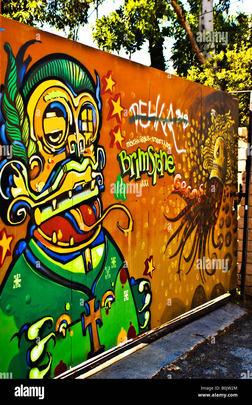 A strange spray painted graffiti wall of a greenish character on an ...