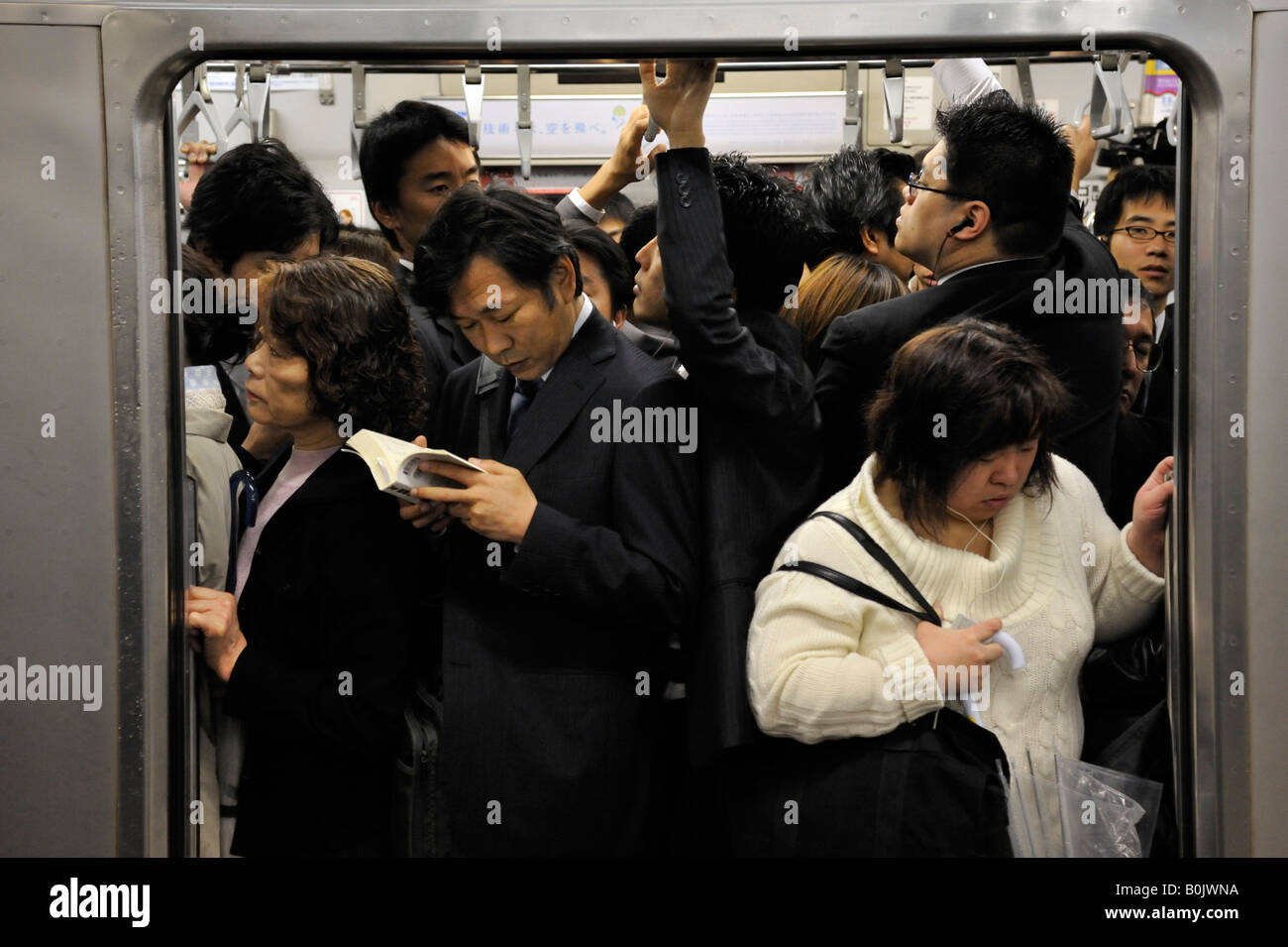 Many commuters in packed railway carriage during rush hour on Tokyo ...