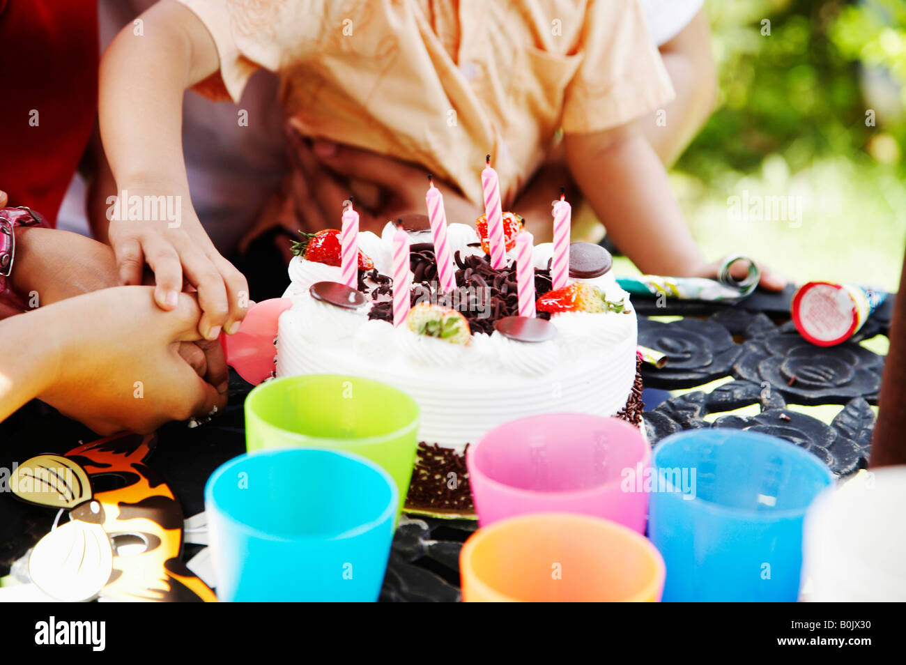 Hands cutting birthday cake together Stock Photo - Alamy