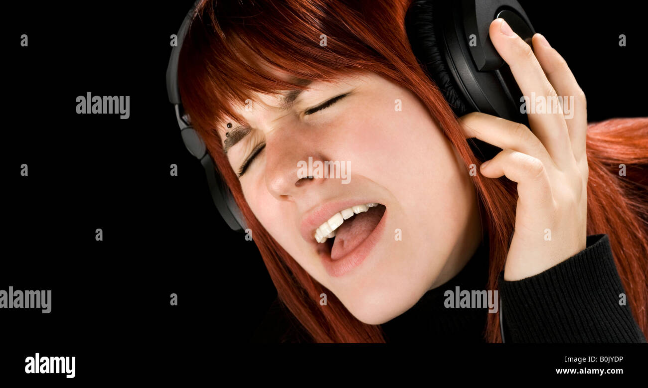 Cute redhead girl enjoying and singing music on her headphones Studio ...