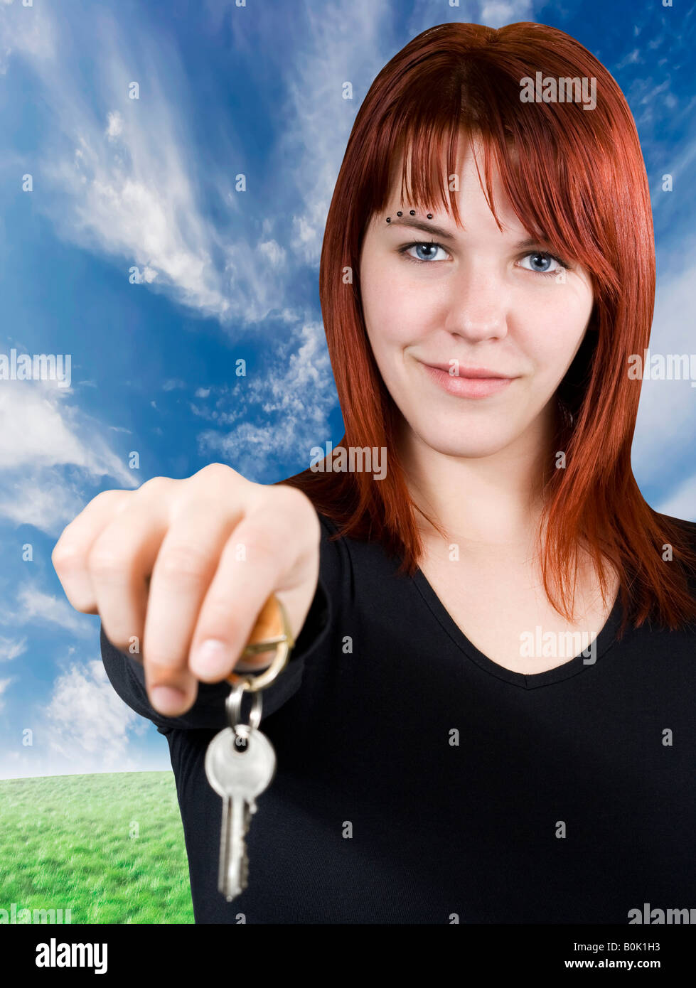 Cute smiling redhead girl holding keys towards the camera Stock Photo ...