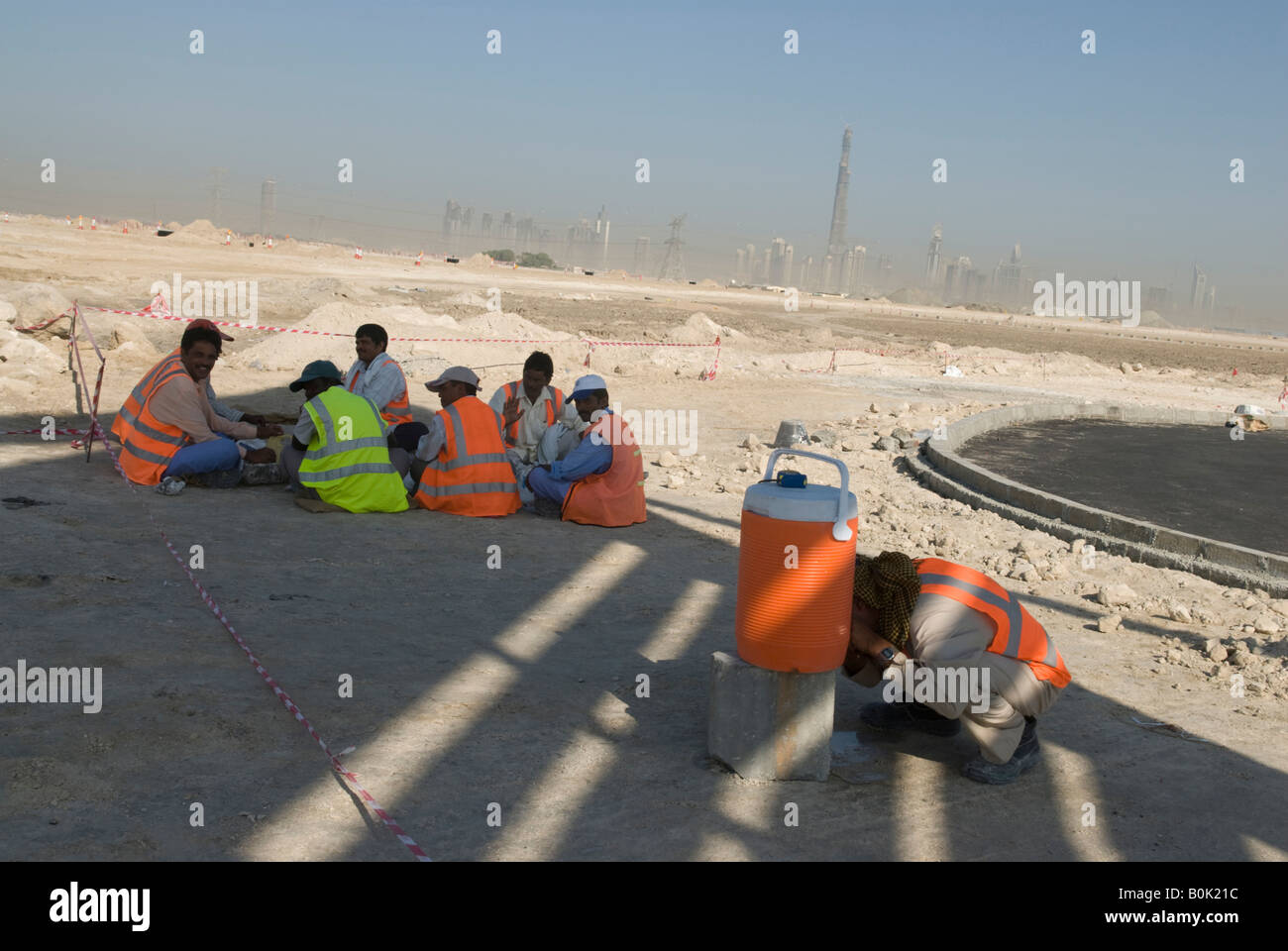 Migrant workers taking a break to drink water and shelter from the sun ...