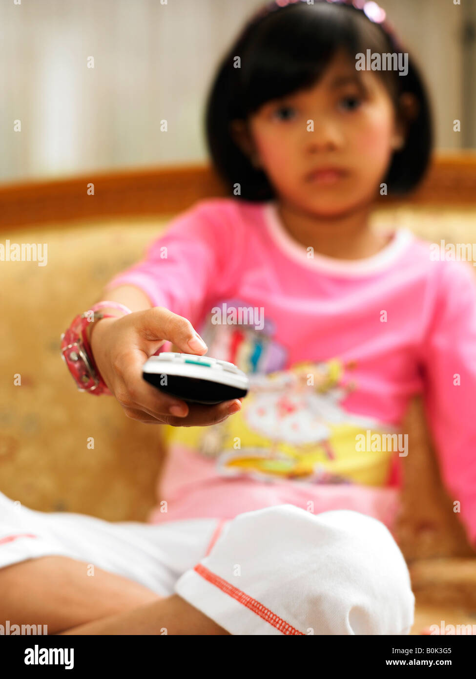 Girl pointing remote control at the camera Stock Photo - Alamy