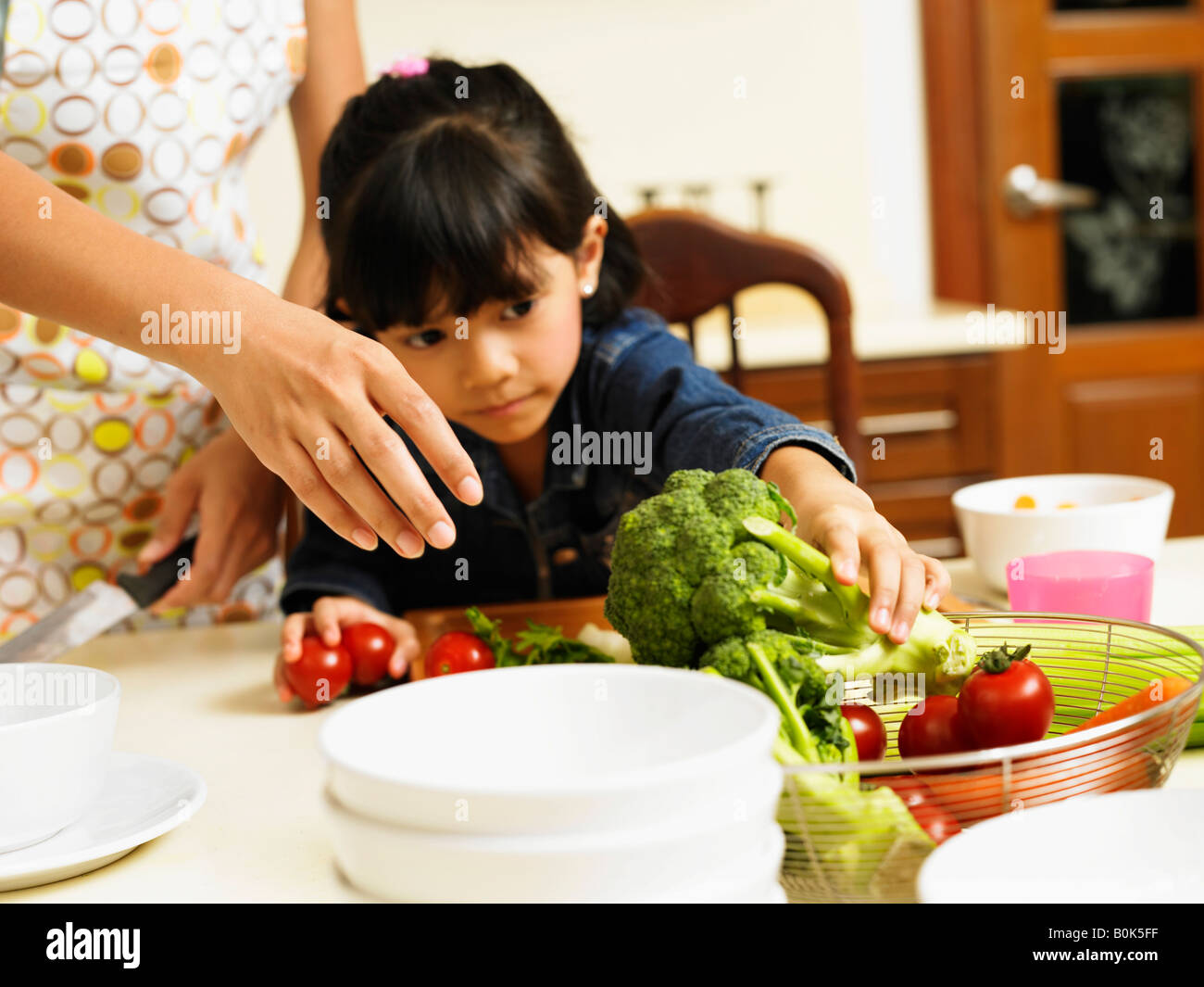 Daughter helping mother cooking Stock Photo - Alamy