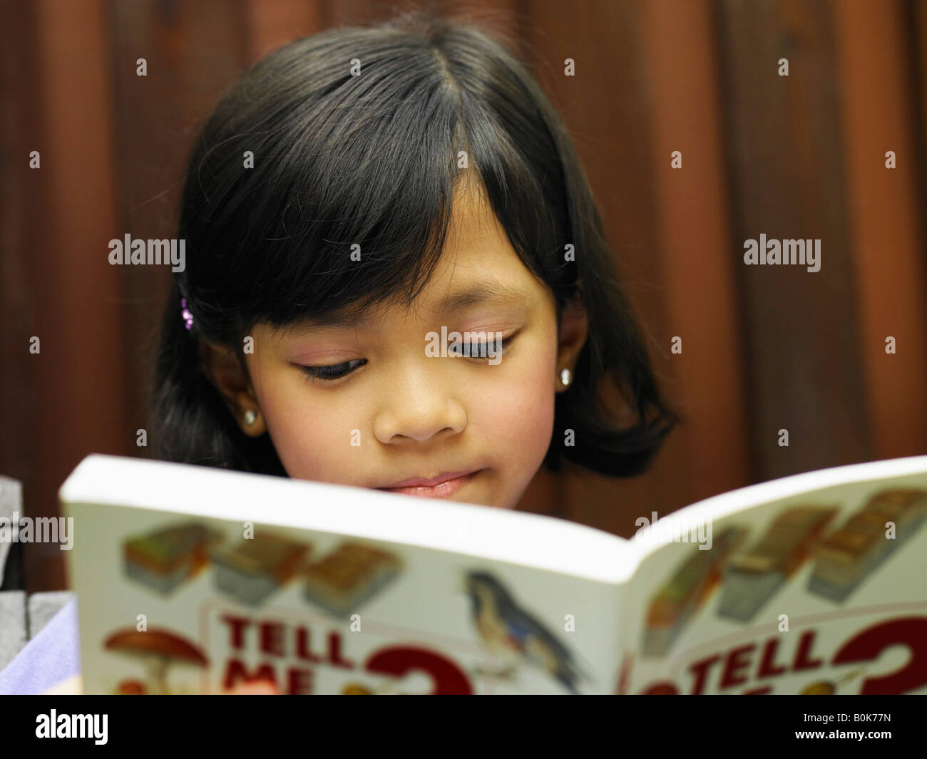 A young girl looking at the book Stock Photo - Alamy