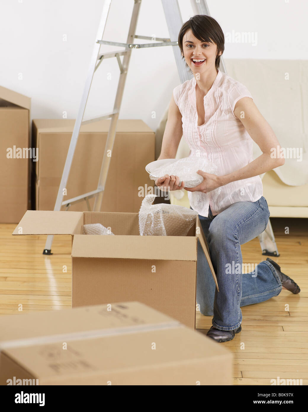 Young Woman Packing Cardboard Boxes Stock Photo - Alamy