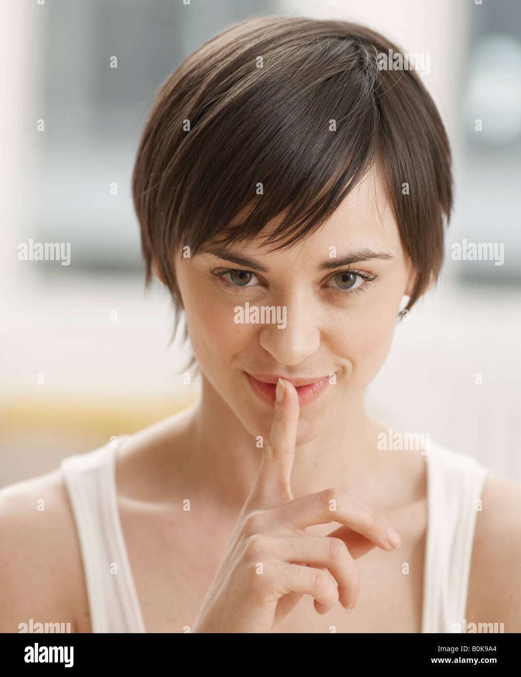 Young Woman with Finger on Mouth Stock Photo - Alamy