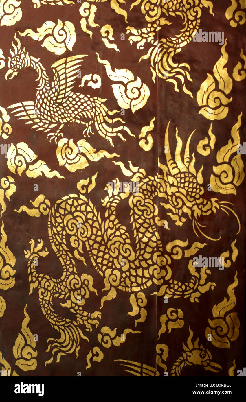 A graphic, gold stenciled pillar of a phoenix and dragon in Asia Stock ...