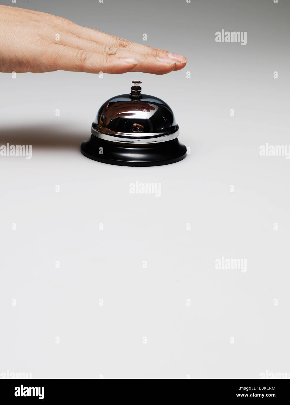 Person's Hand on Desk Bell Stock Photo - Alamy