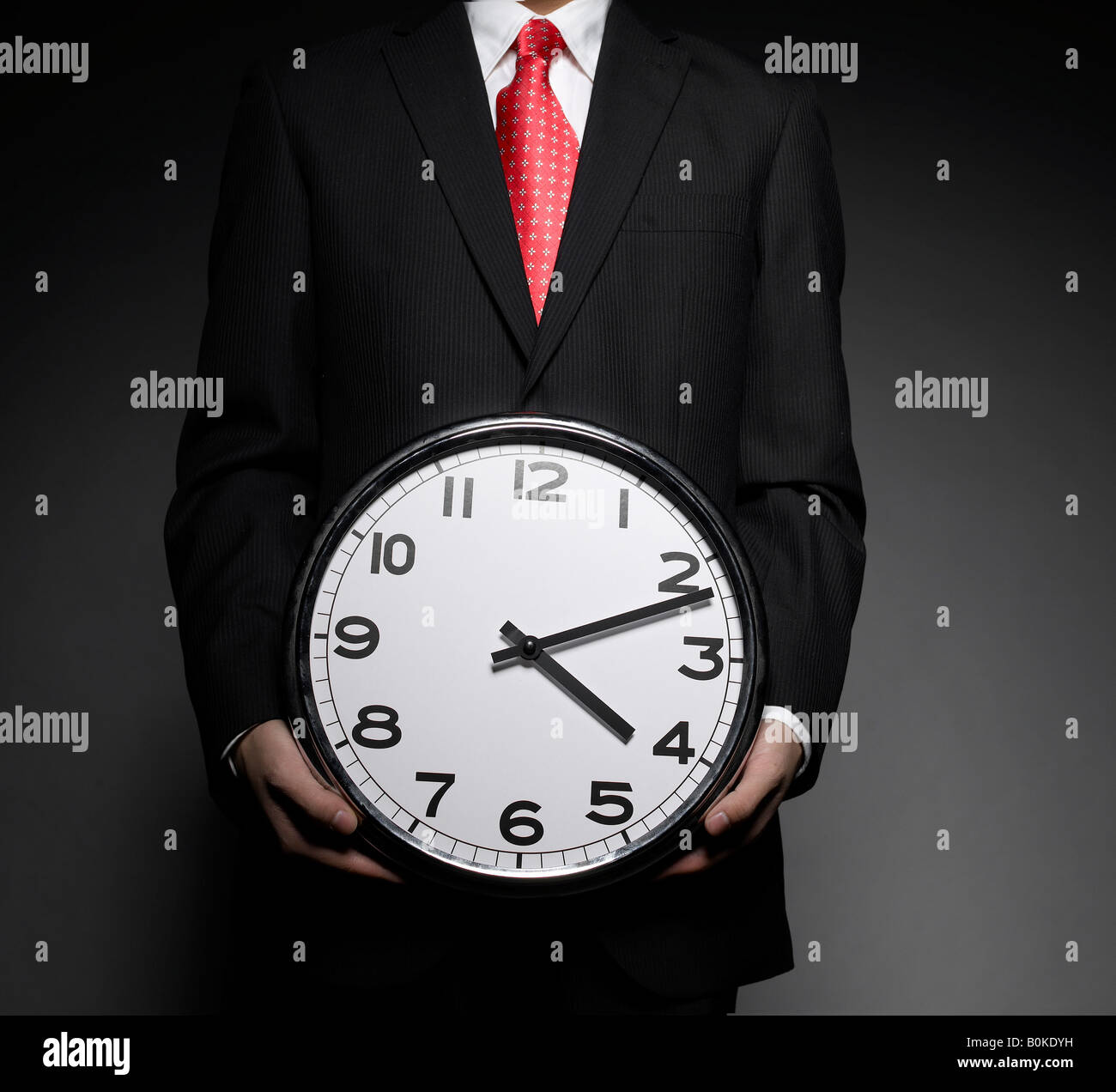 Businessman Holding Clock Stock Photo - Alamy