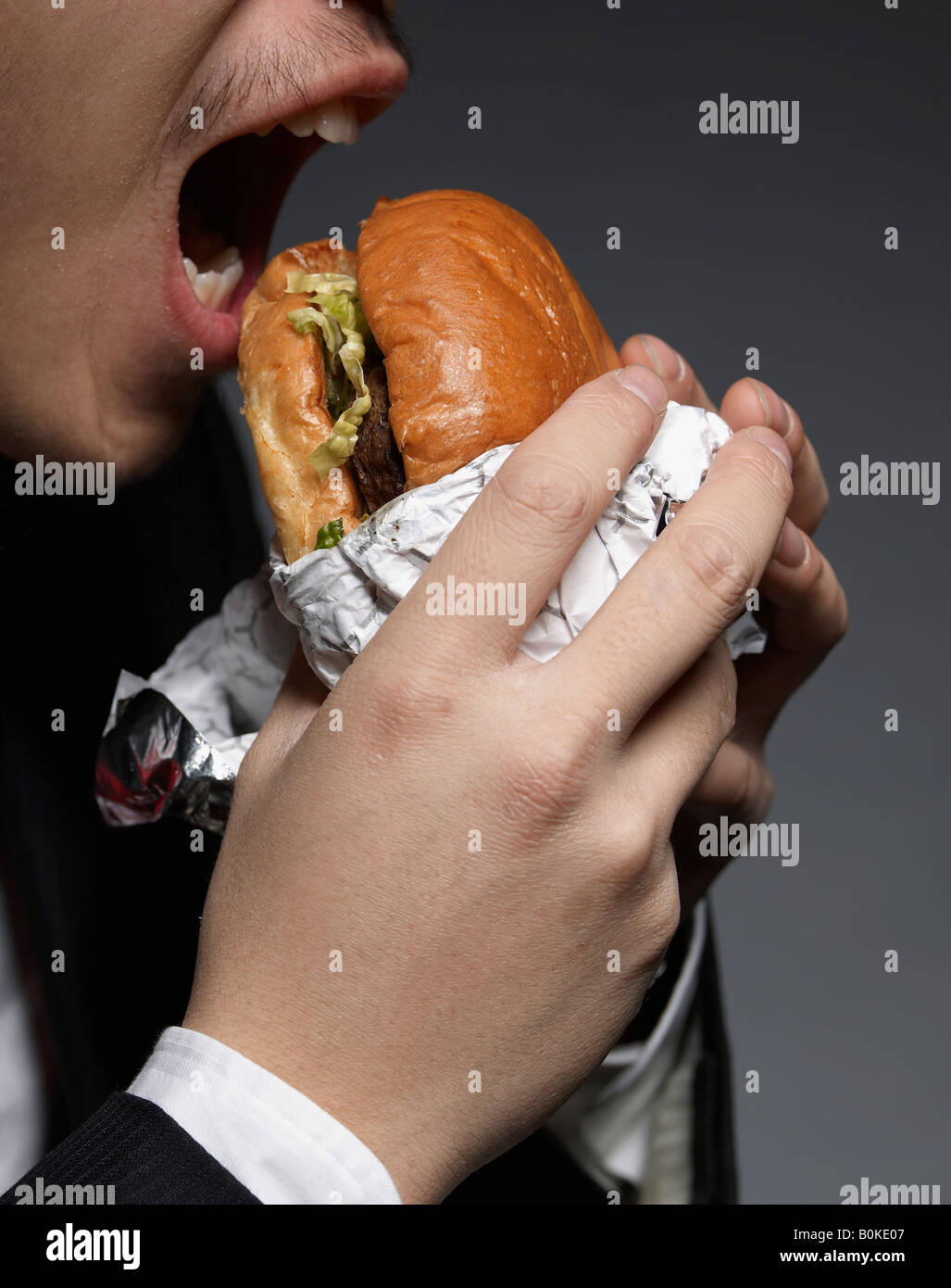 Businessman eating hamburger hi-res stock photography and images - Alamy