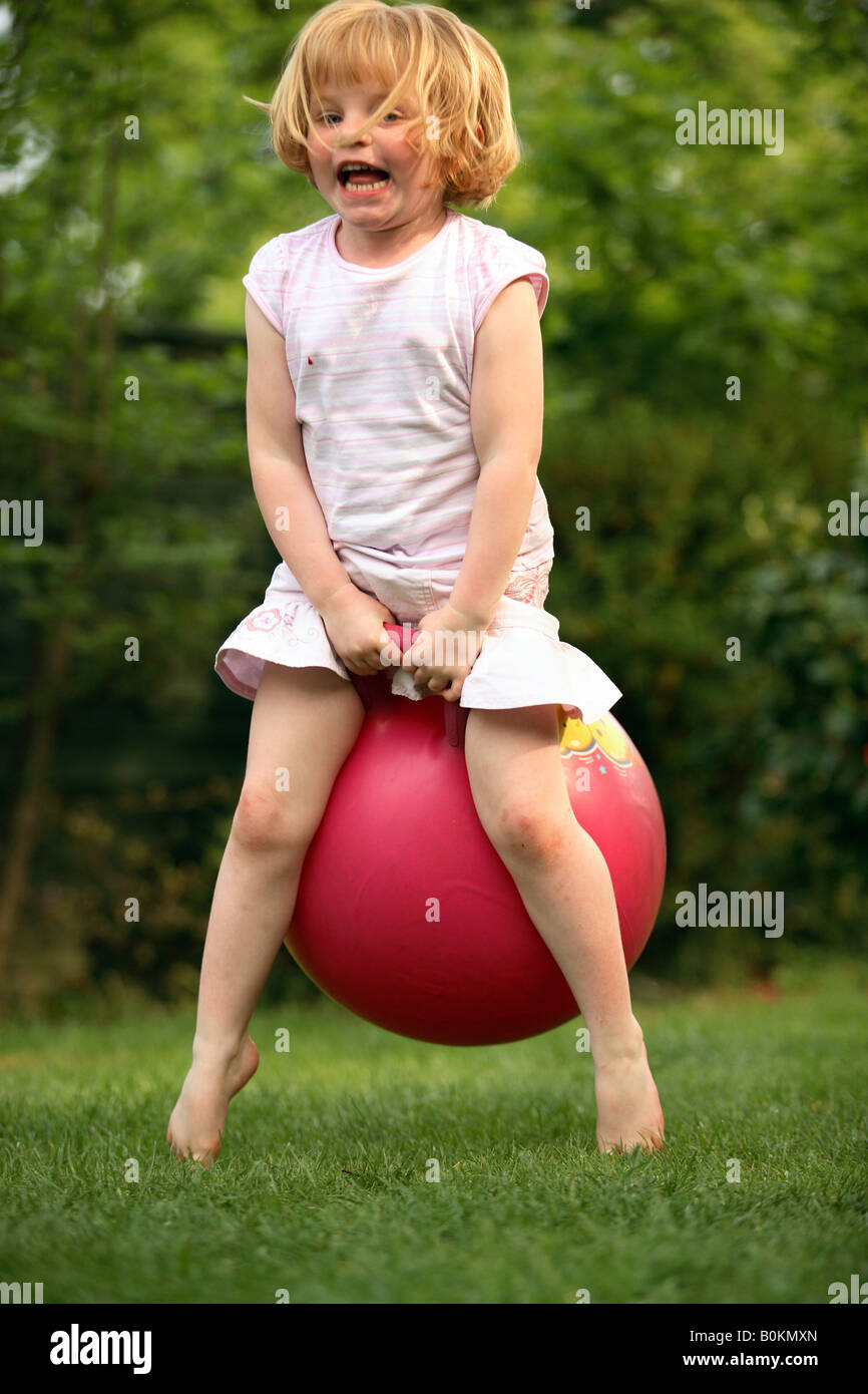 Child bouncing on spacehopper toy Stock Photo - Alamy