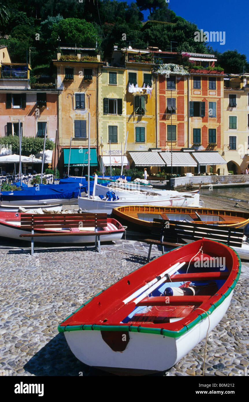 Colourful houses on the waterfront overlook small boats resting on the ...