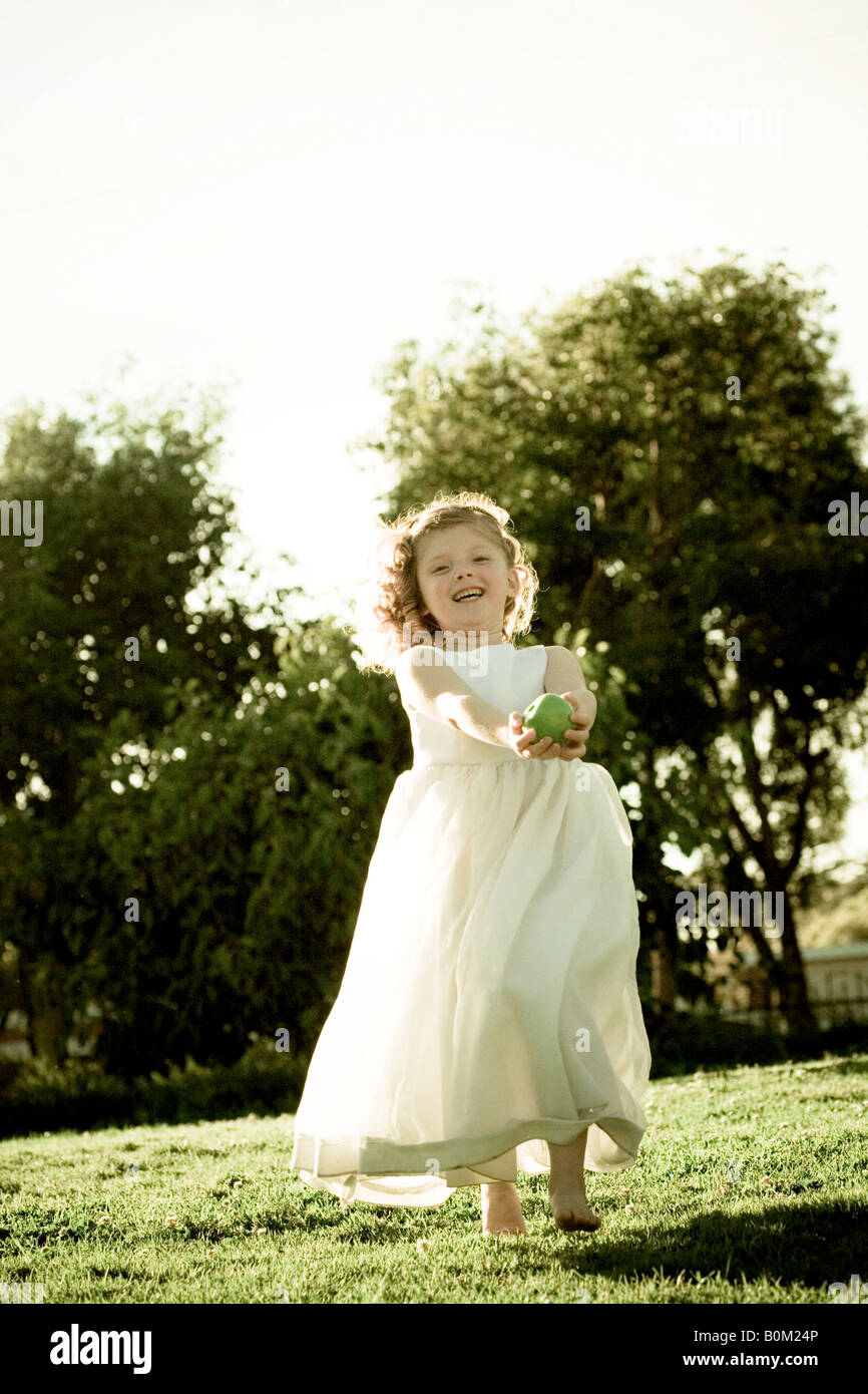girl, running with green apple in her hands outstretched ready to give ...