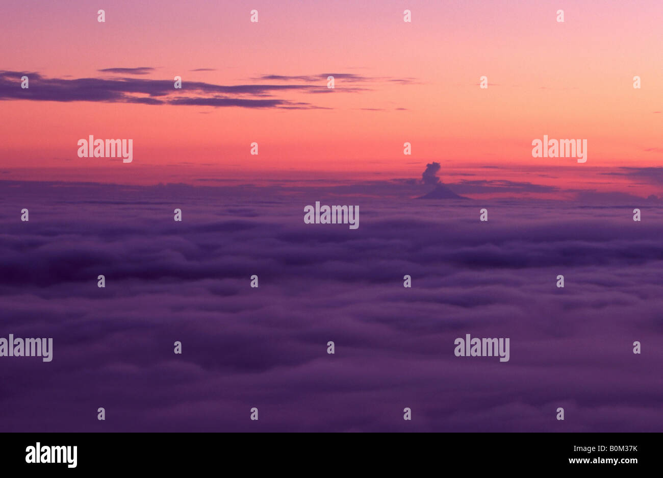 The Mt. Augustine volcano releases steam during sunset as seen acrossed ...