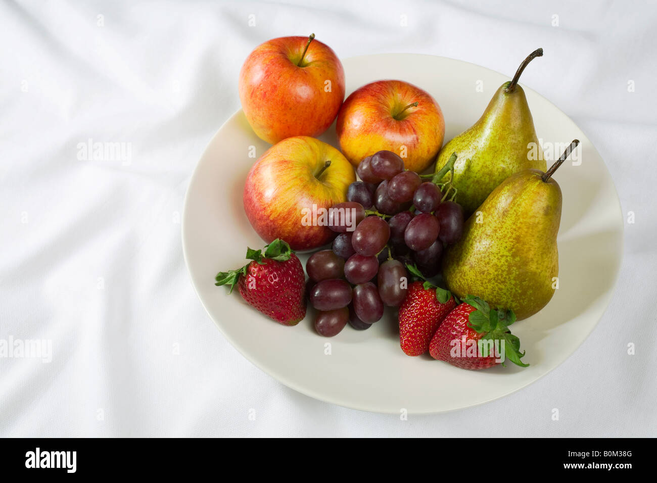 Fruit plate over white fabric Stock Photo - Alamy