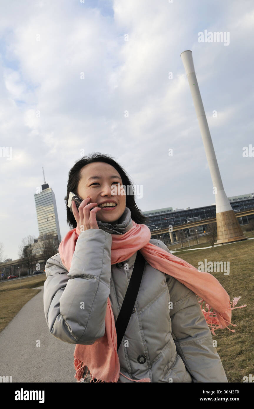 Young chinese woman calling with a cell phone in front of the Ericsson ...