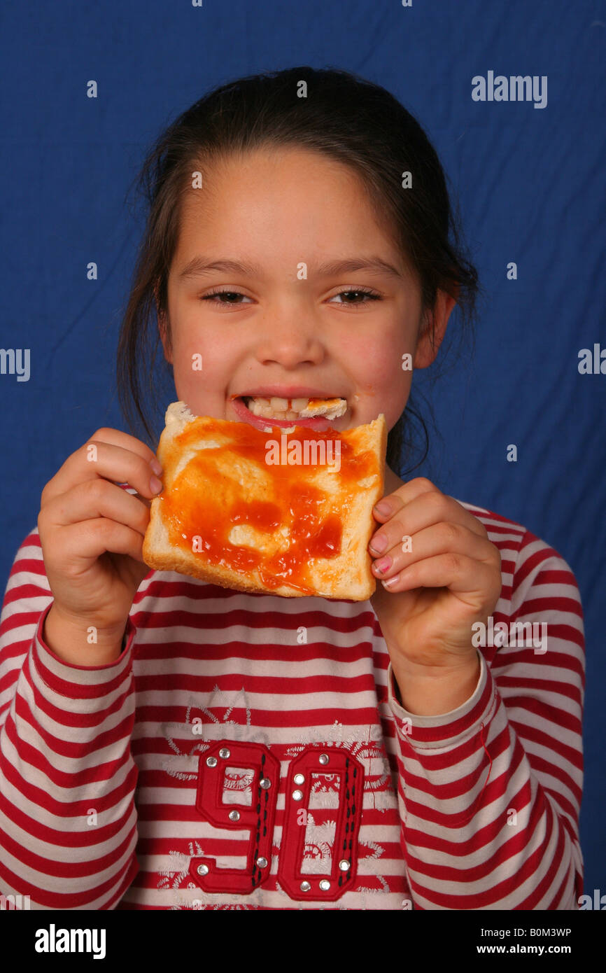 Young girl eating a jam sandwich Stock Photo - Alamy