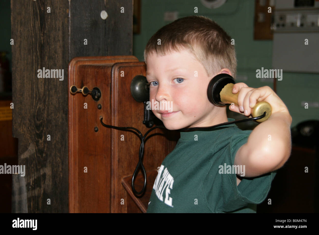 A boy interacting with an antique phone Stock Photo - Alamy