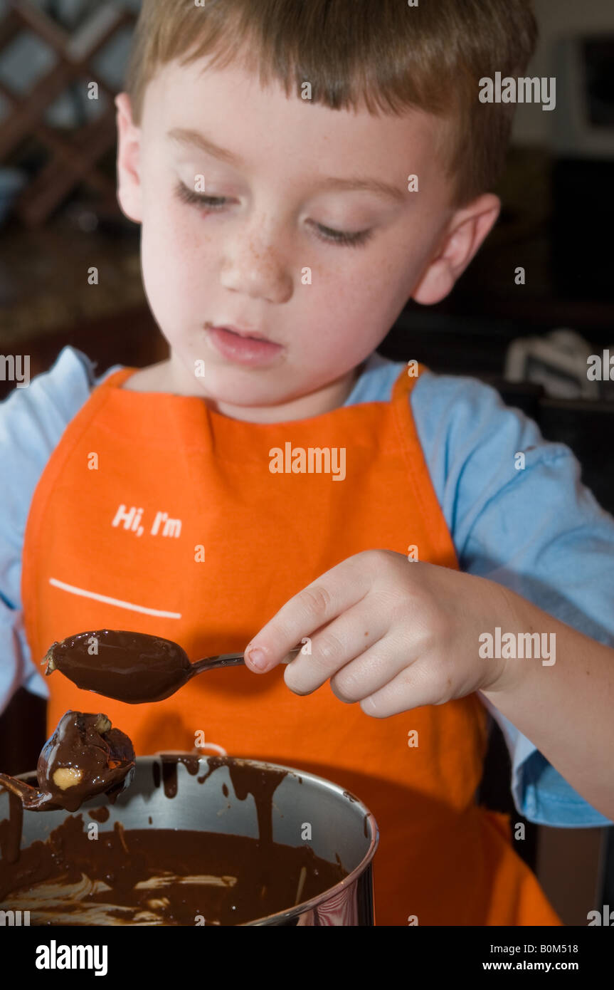 Family activity making home made chocolate covered peanut butter eggs a ...