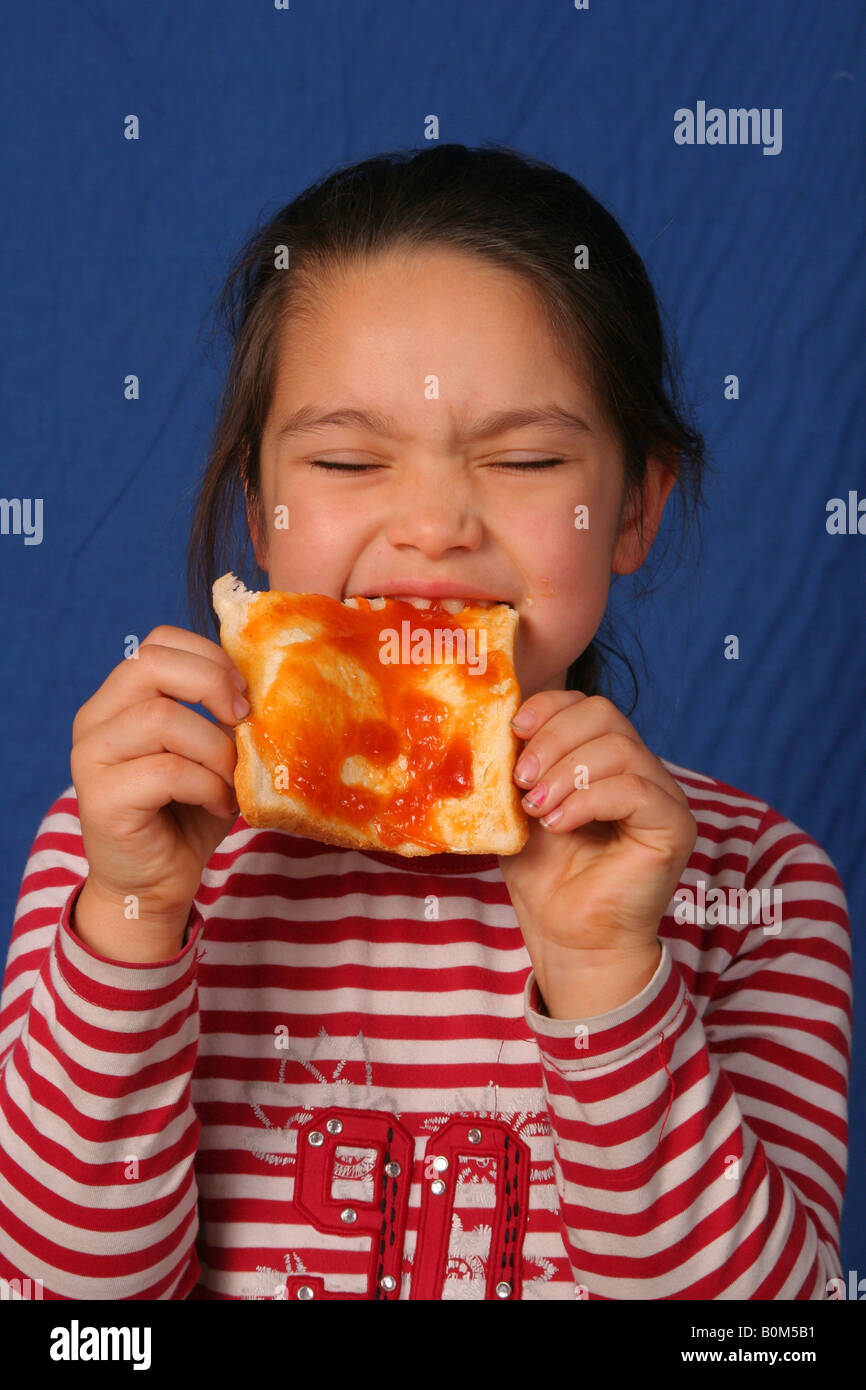 Young girl eating a jam sandwich Stock Photo - Alamy