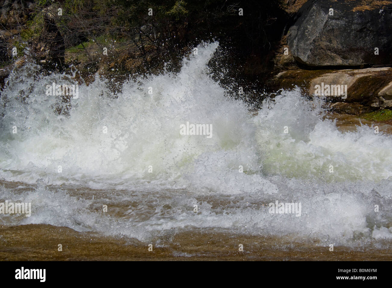 Rapidly flowing water of the Merced River on the granite apron above ...