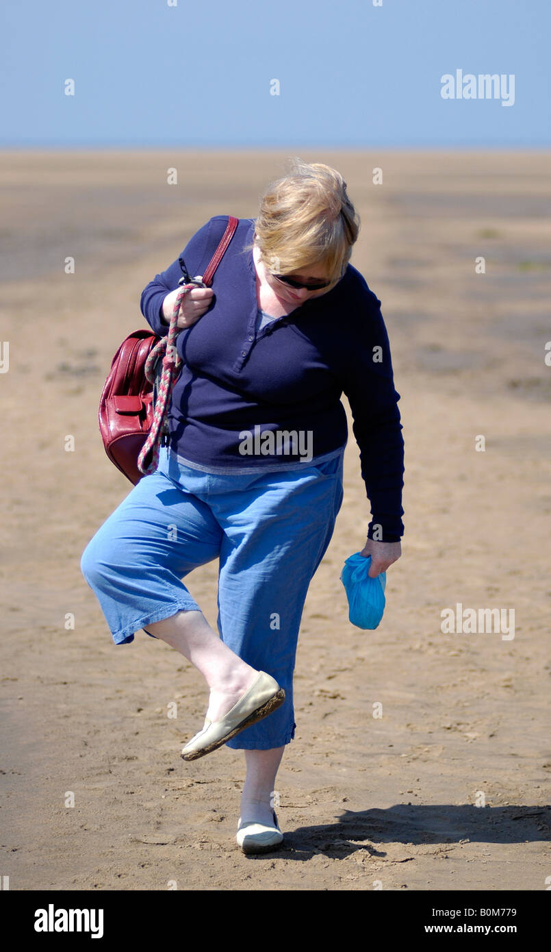 woman checking shoes for dirt and sand Stock Photo - Alamy