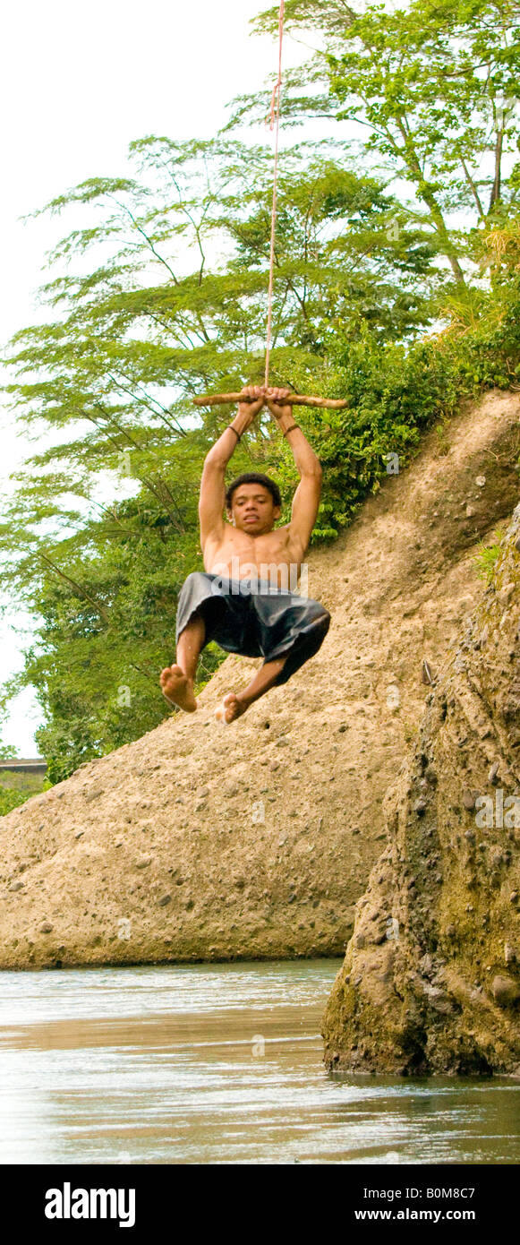 COSTA RICA Teenager swinging on rope into the Lower Pacuare River ...