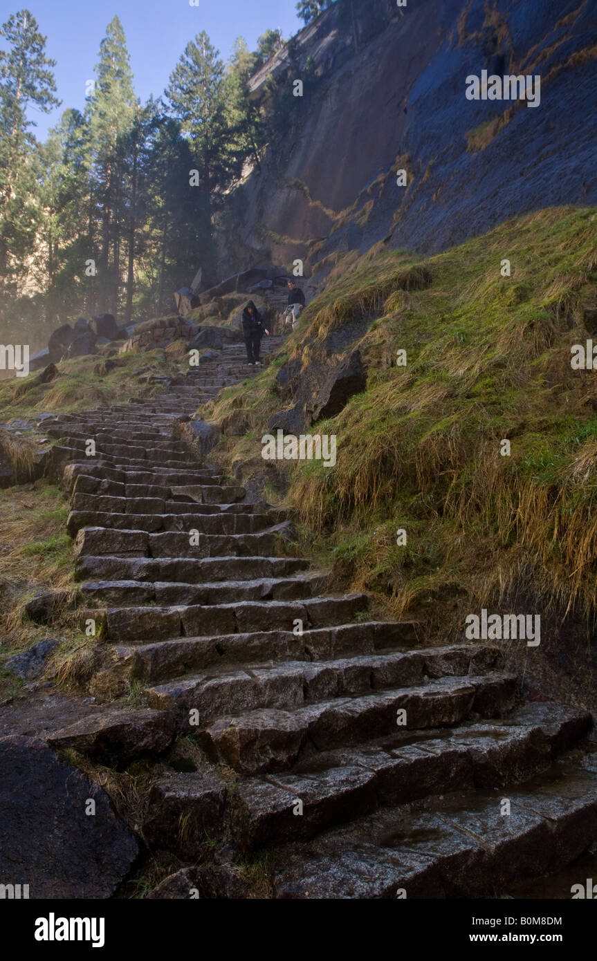 Hikers descending the steep rocky staircase stairs of the Mist Trail ...