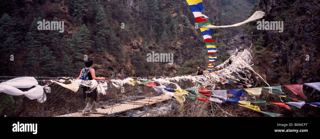 Girl crossing bridge with prayer flags hi-res stock photography and ...
