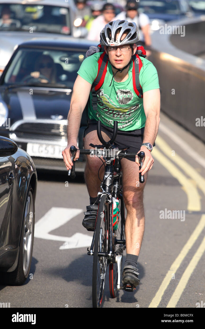 Cyclist riding through the busy traffic streets of Westminster London ...