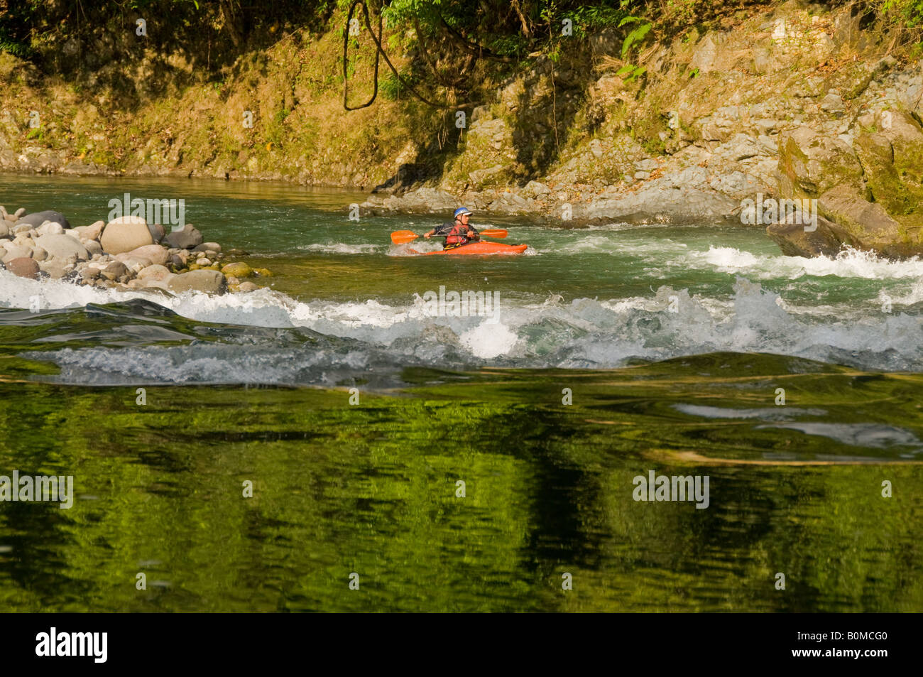COSTA RICA Rainforest river reflections on whitewater rapids kayaker ...