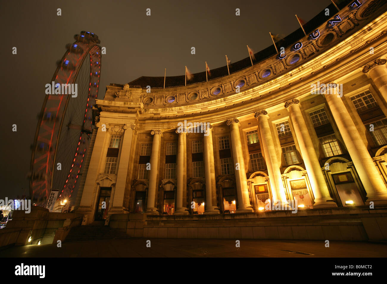 City of London, England. Night view of County Hall with the London Eye ...