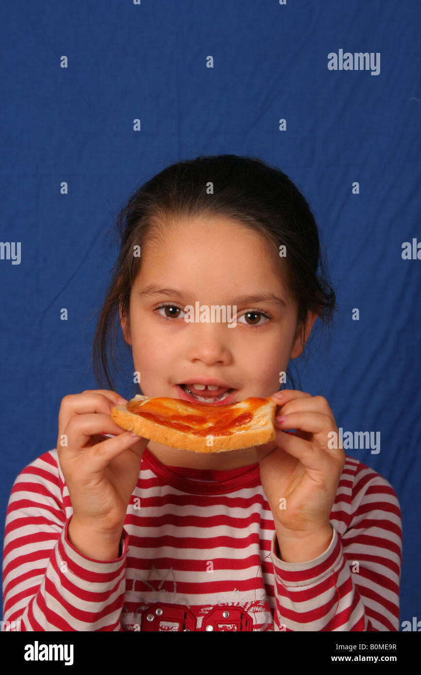 Young girl eating a jam sandwich Stock Photo - Alamy