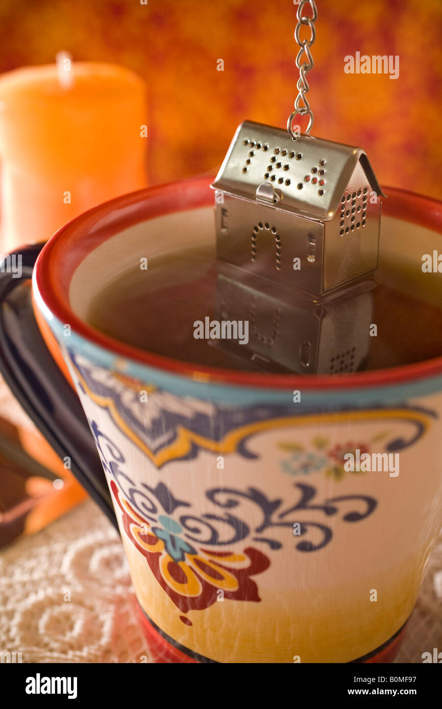 Warm tea cup showing tea infuser hanging on the tea surface Stock Photo ...