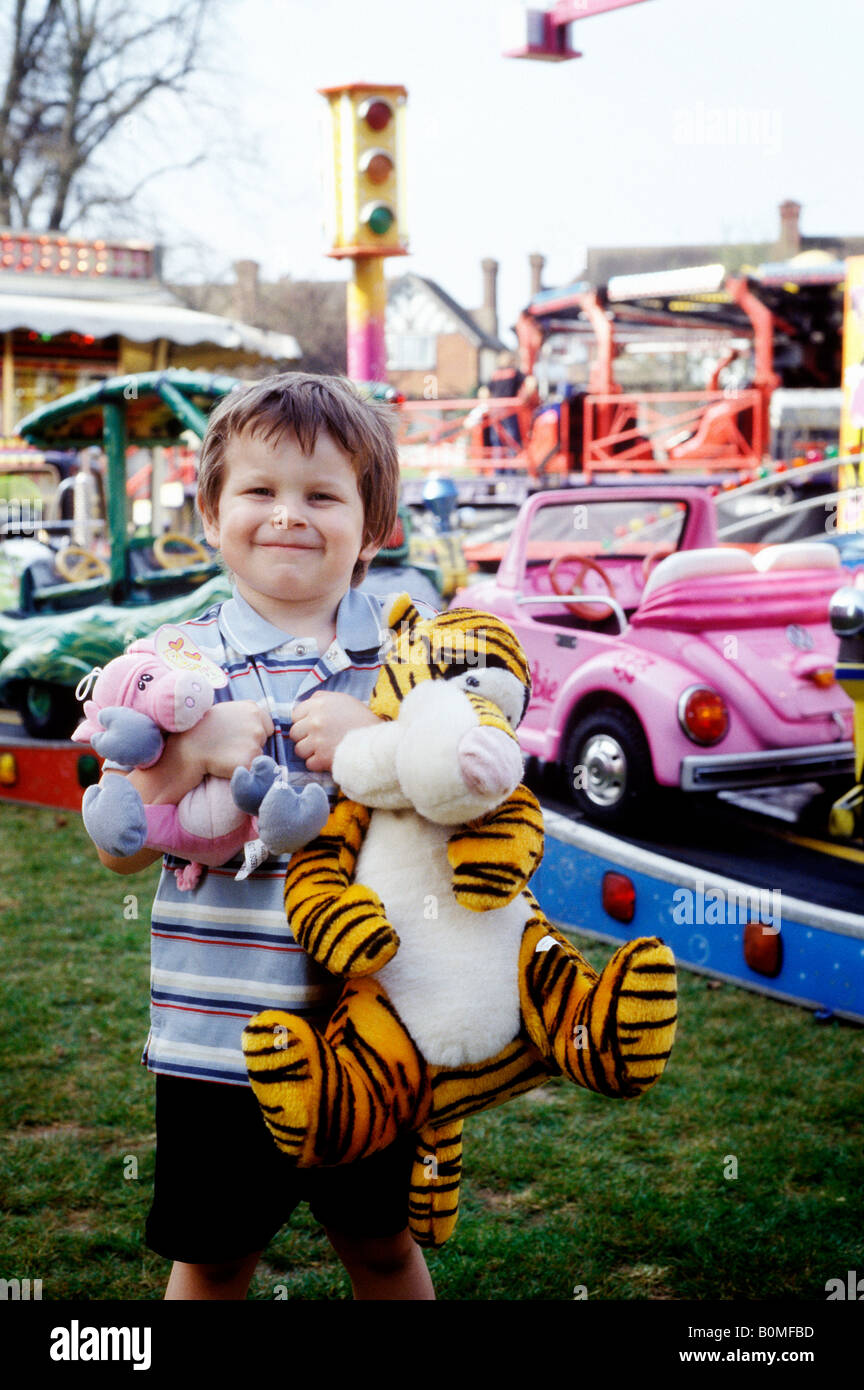 a young boy with prizes at a funfair Stock Photo - Alamy