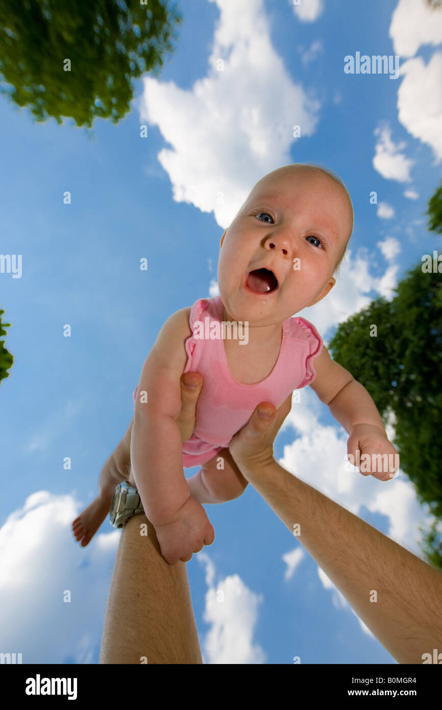 Baby girl flying in a sky on parent hands Stock Photo - Alamy