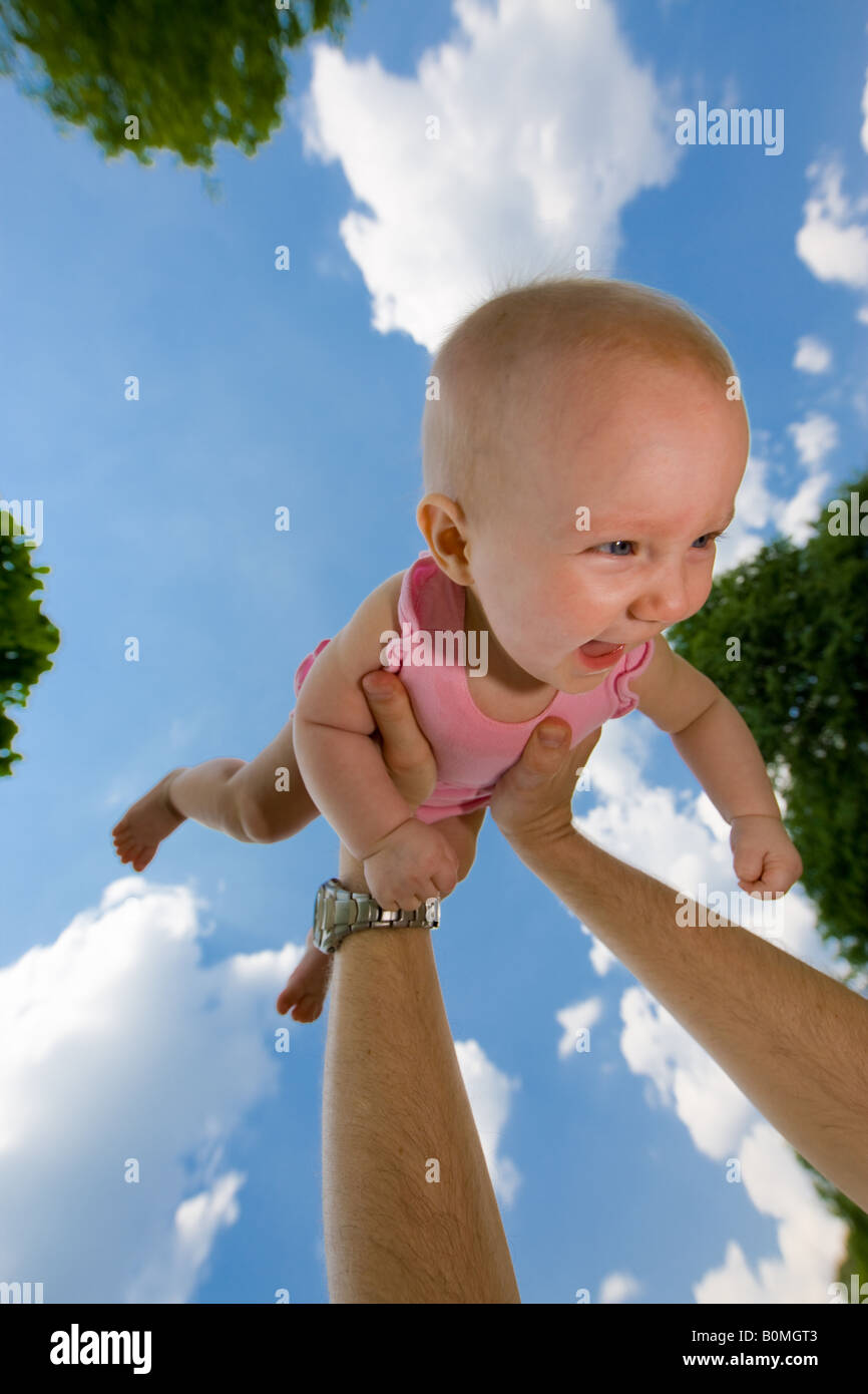 Baby girl flying in a sky on parent hands Stock Photo - Alamy