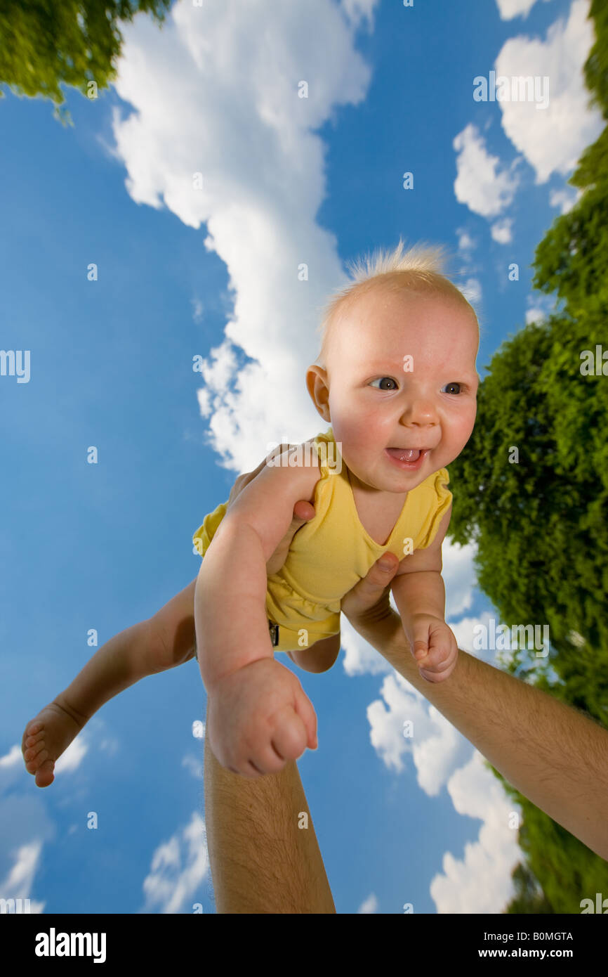 Baby girl flying in a sky on parent hands Stock Photo - Alamy