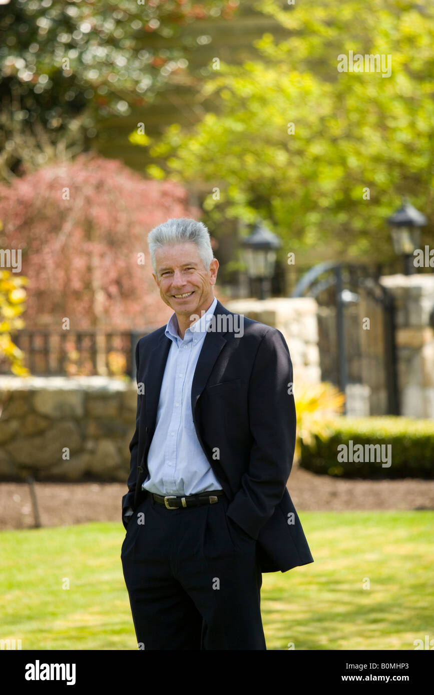 Male realtor standing outside in front of home for sale Stock Photo - Alamy