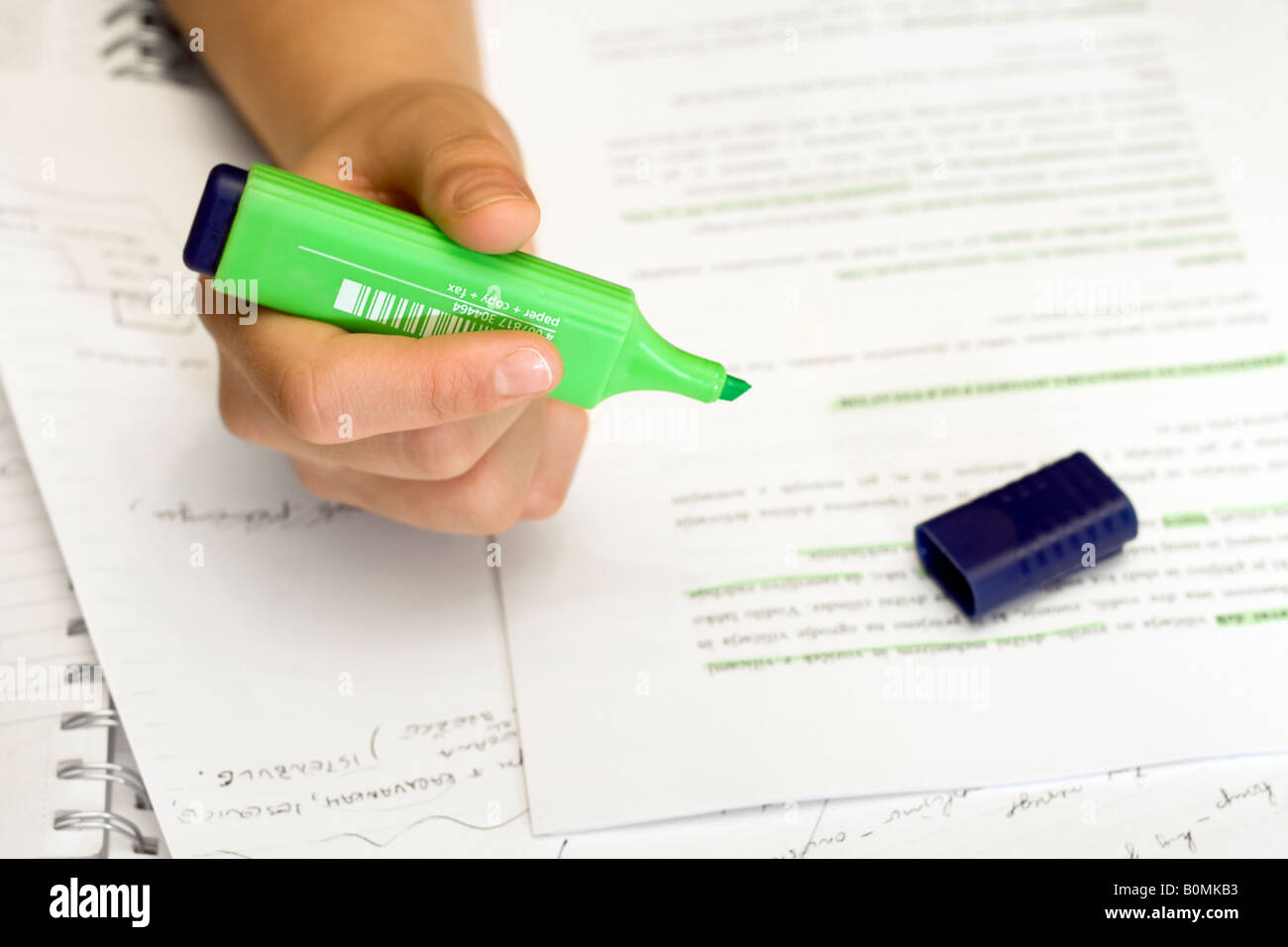 Closeup of a hand of a student using a green marker while studying ...