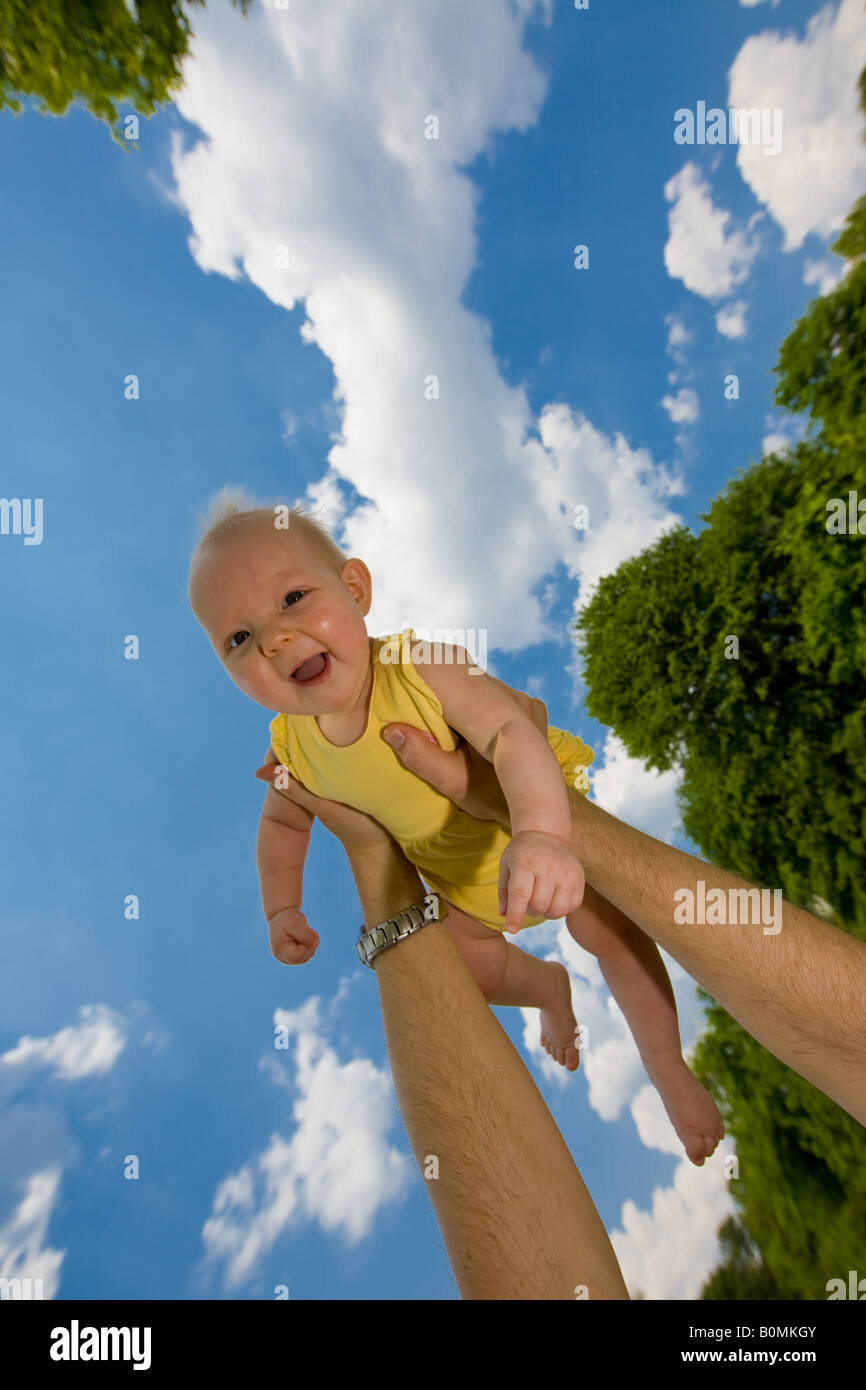 Baby girl flying in a sky on parent hands Stock Photo - Alamy