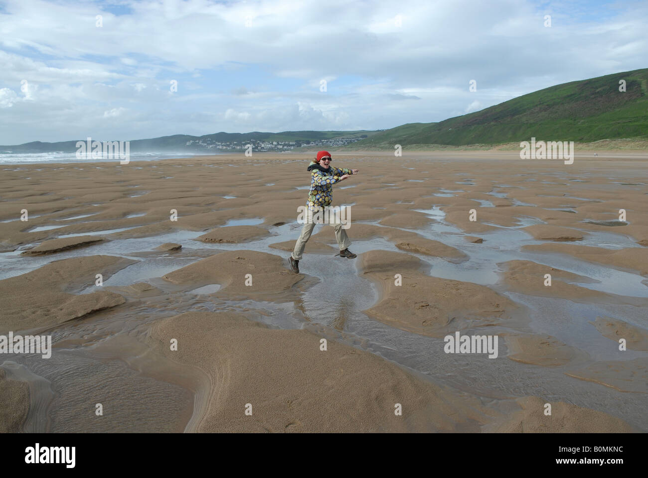 A holidaymaker enjoys a moment of solitude on a deserted beach near ...