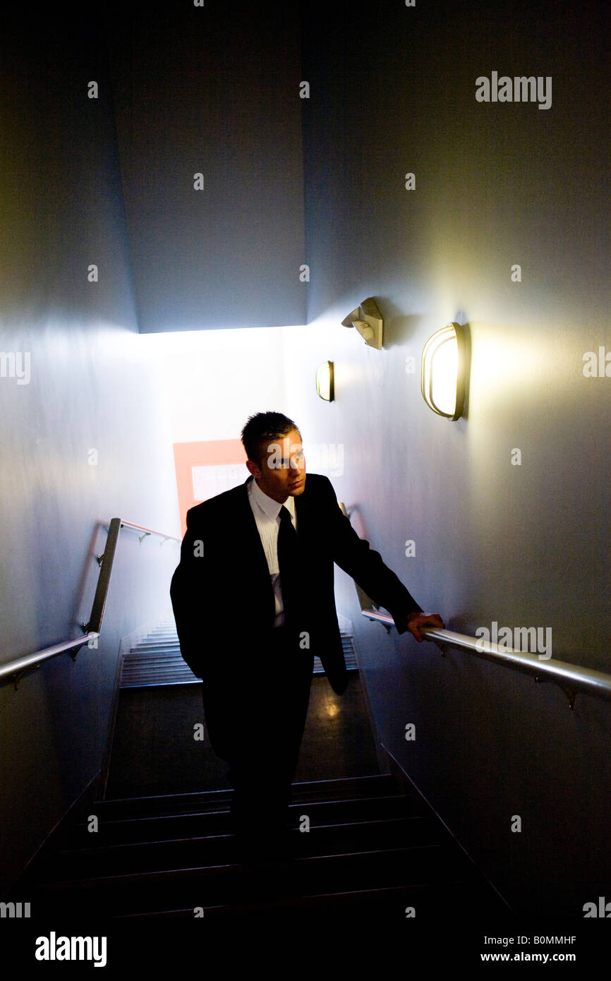 Man in suit waiting in dramatic stairwell Stock Photo - Alamy