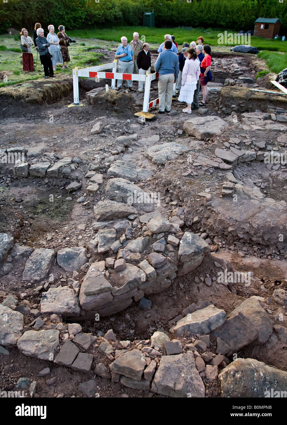Tour group in the ruins of the excavated medieval town of Trellech ...