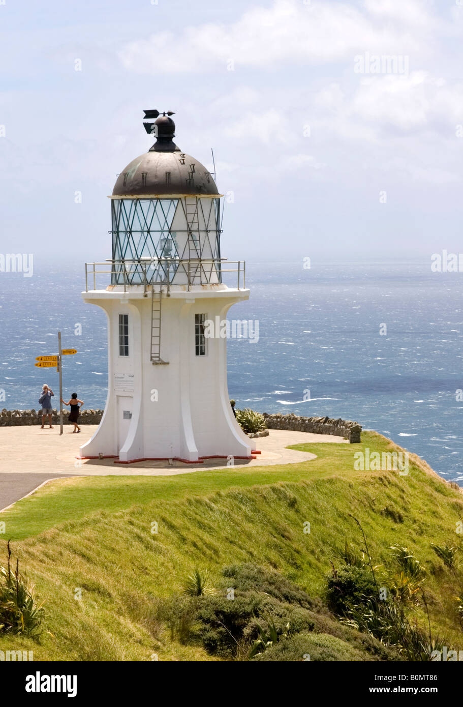 Cape Reinga lighthouse with two tourists taking a photograph Stock ...
