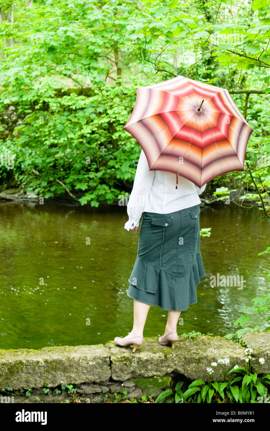 woman standing on riverbank holding umbrella Stock Photo - Alamy